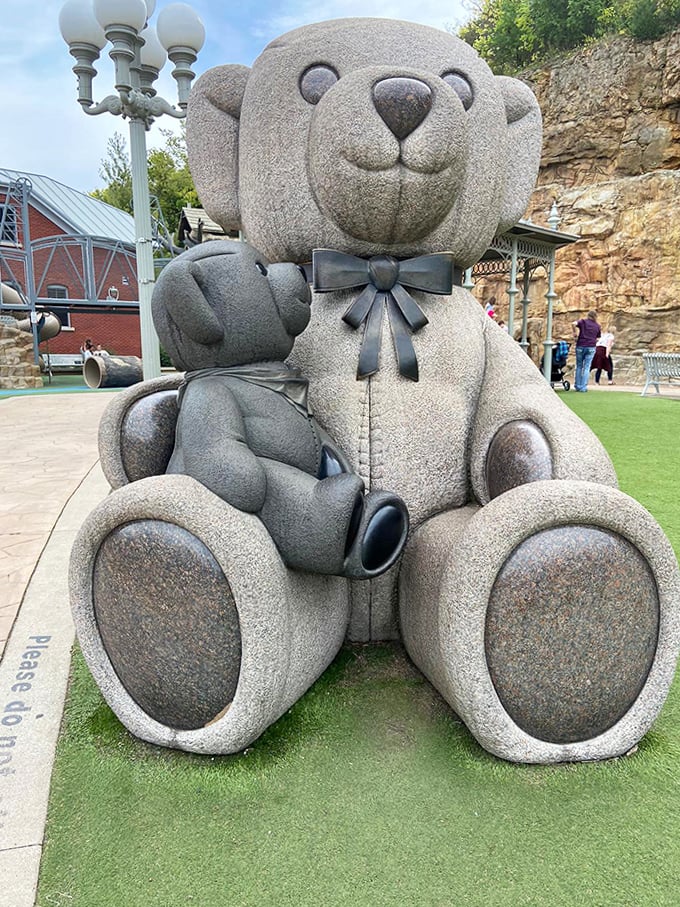 This isn't just any teddy bear &ndash; it's a massive stone guardian of childhood joy, complete with a dapper bow tie.