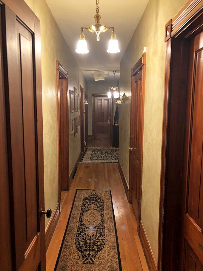 Hallway: Warm wood tones and period lighting transform a simple corridor into a passage through time, where every step echoes with history.
