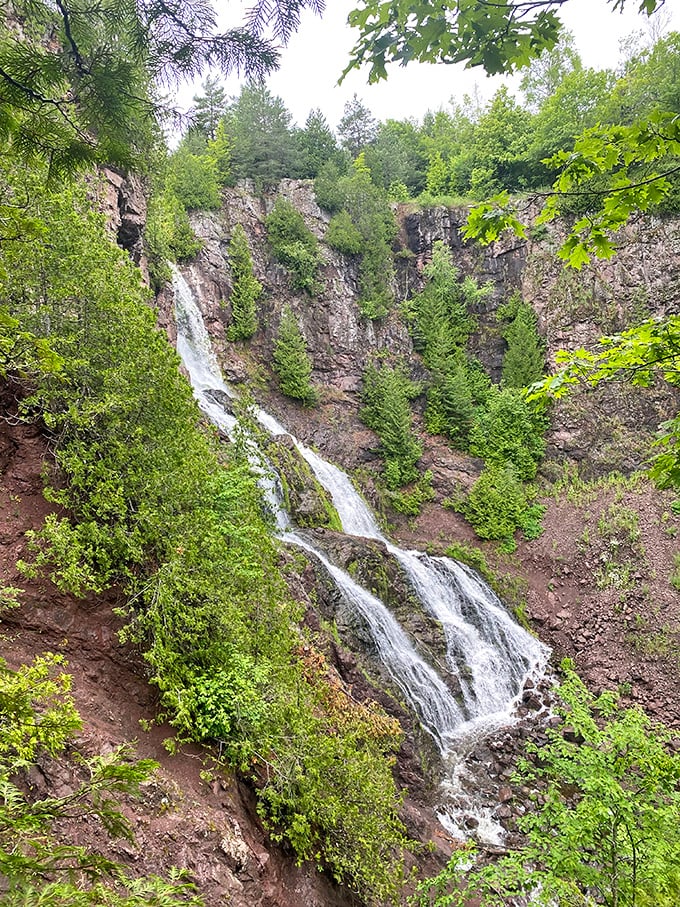 The waterfall's multiple tiers create nature's perfect staircase. Each level seems to pause dramatically before continuing its journey downward, like a theatrical performance in liquid form.