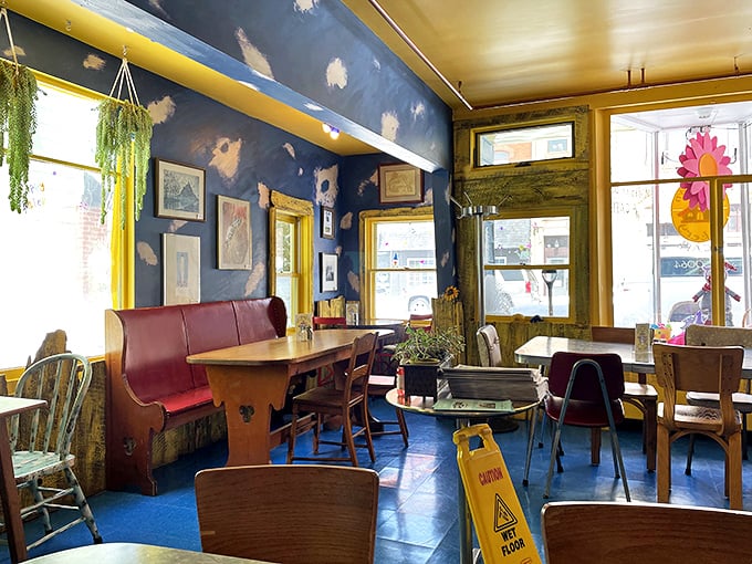 Inside, deep blue walls and mismatched furniture create a cozy atmosphere where conversations flow as freely as the coffee.