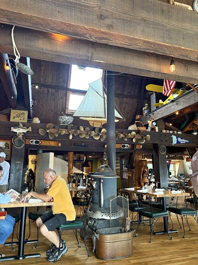 Nautical nostalgia meets cozy comfort inside The Cove, where ship propellers, vintage wood beams, and a central potbelly stove transport diners to simpler times.