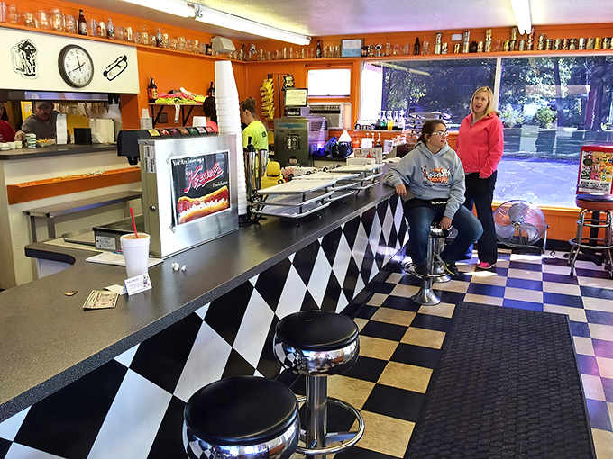 Classic black and white checkered floors meet vibrant orange walls, where counter service and nostalgia are always on the menu.