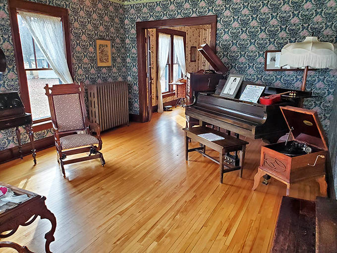 Step back in time in this meticulously preserved parlor where vintage wallpaper and period furniture create an authentic early 20th-century atmosphere.