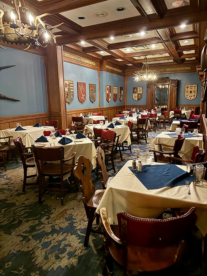 Interior: Step into a royal banquet hall where wooden beams frame blue walls adorned with family crests, creating an atmosphere of old-world European elegance.