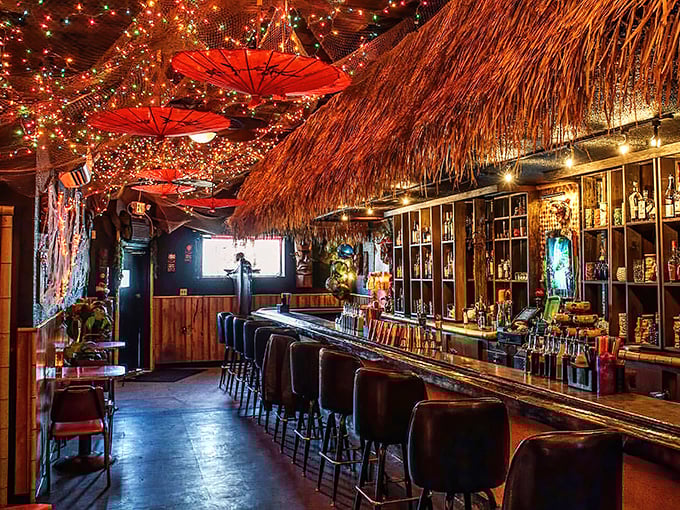 Tiki paradise awaits inside, where blue fishing floats glow like captured ocean treasures above patrons enjoying exotic libations.