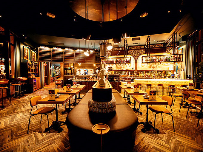 Step inside to discover a warm, sophisticated interior where herringbone floors lead to comfortable seating and a stunning central sculpture.