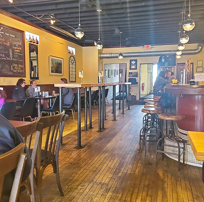 Warm yellow walls, wooden floors, and globe pendant lights create a cozy atmosphere that's equal parts neighborhood tavern and space-age pizzeria.