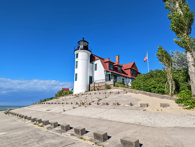 Perched majestically on its sandy hill, the lighthouse commands attention against a brilliant blue sky.