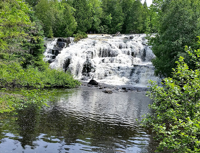 Manabezho Falls cascades over ancient volcanic rock, creating a symphony of sound and spray that's been performing the same show for millennia.