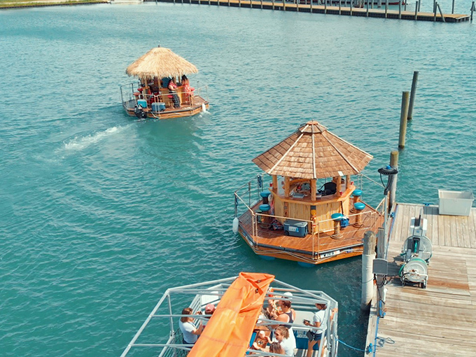 Multiple tiki boats lined up like a fleet of floating beach bars, because apparently one wasn't enough to contain all this fun.