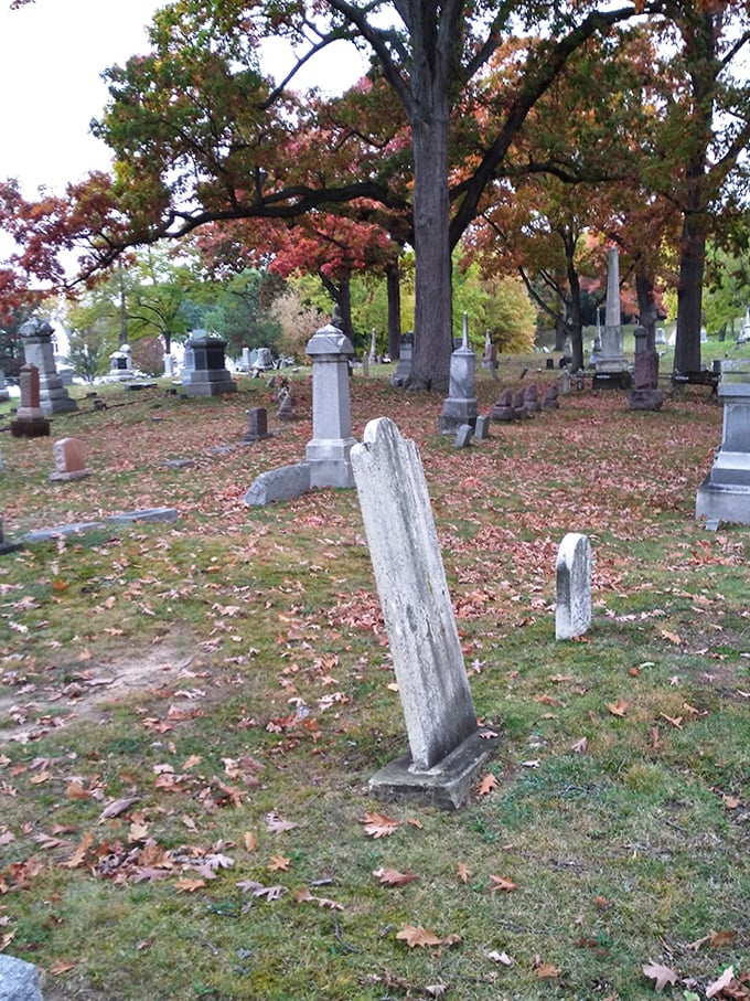 Time and elements have tilted this weathered marker, creating an unintentional artistic statement about mortality and the passage of years.