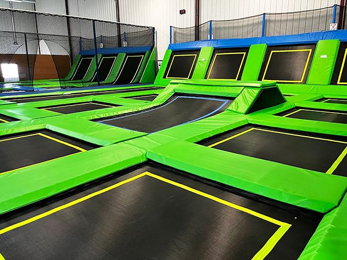 A sea of green trampolines stretches before you, each square promising the weightless joy that only defying gravity can deliver.