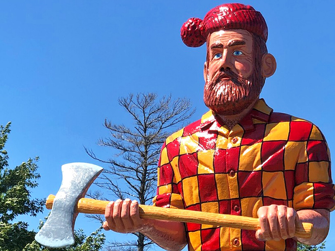 Paul's weathered face tells stories of mythical logging feats, his red cap and checkered shirt vibrant against the northern Michigan sky.