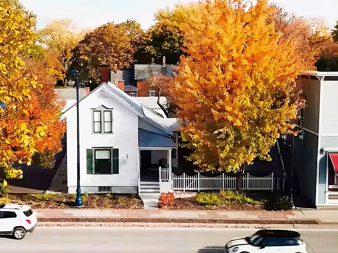 Autumn leaves frame this charming white house, standing proudly like a time capsule waiting to be opened.
