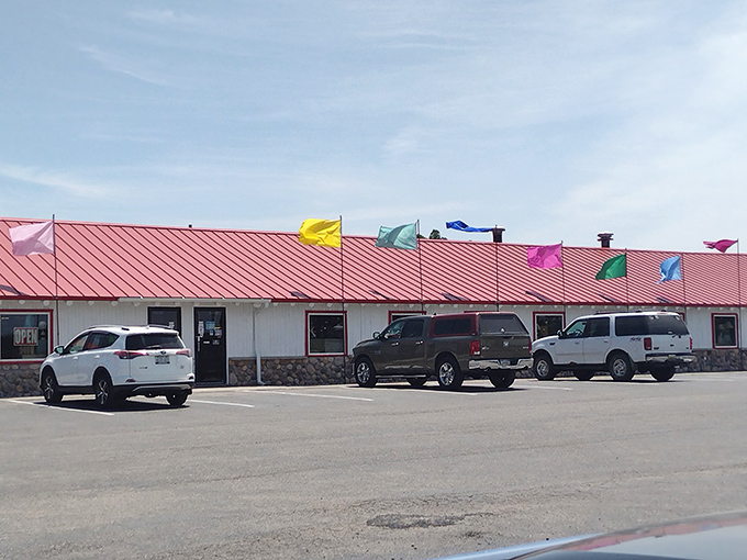 The welcoming storefront with its vibrant flags creates an irresistible invitation to curious travelers seeking maritime treasures and coastal curiosities.