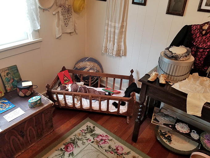 Step back in time with this cozy bedroom display featuring a vintage wooden cradle and handmade textiles that speak to simpler, handcrafted times.