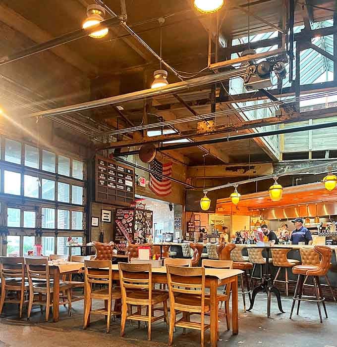 Interior: High ceilings and industrial charm preserve the garage's soul, while leather seating and warm lighting transform it into a dining haven where mechanics once worked.