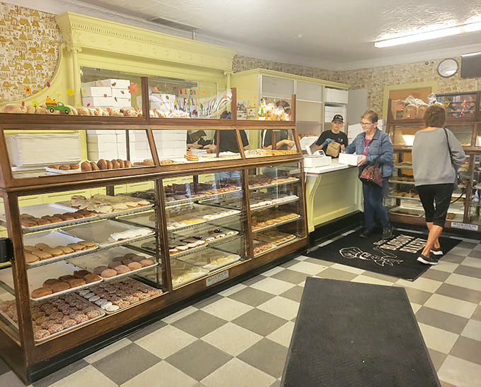 Inside, time stands still with vintage display cases showcasing edible artwork, while the checkerboard floor has witnessed generations of sugar-seeking pilgrims.