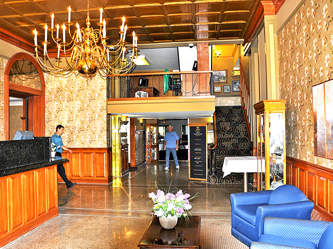 Step into the elegant lobby where classic chandeliers and rich wood paneling create an atmosphere of timeless sophistication and small-town welcome.