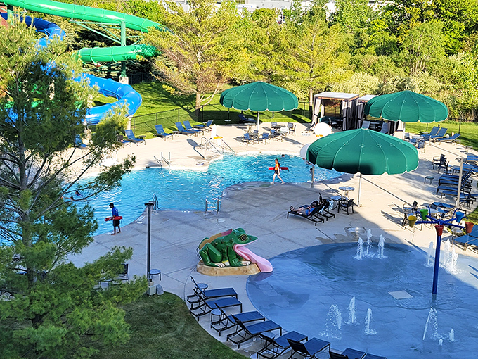 Sunshine meets splashes at the outdoor oasis, where green umbrellas stand guard over crystal waters and the twisting water slide promises thrilling escapes.