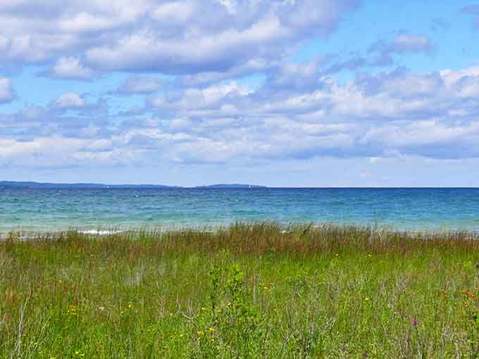 The Great Lakes work their magic where sky meets water, creating that distinctive Michigan blue that somehow looks photoshopped even in real life.