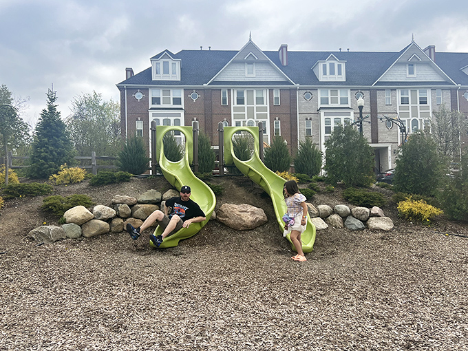 Bright green slides nestled against brick townhomes create the perfect juxtaposition of dignified architecture and undignified fun for all ages.