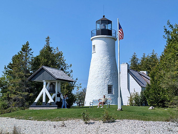 Against a perfect blue Michigan sky, the lighthouse gleams like a freshly painted chess piece on nature's board.