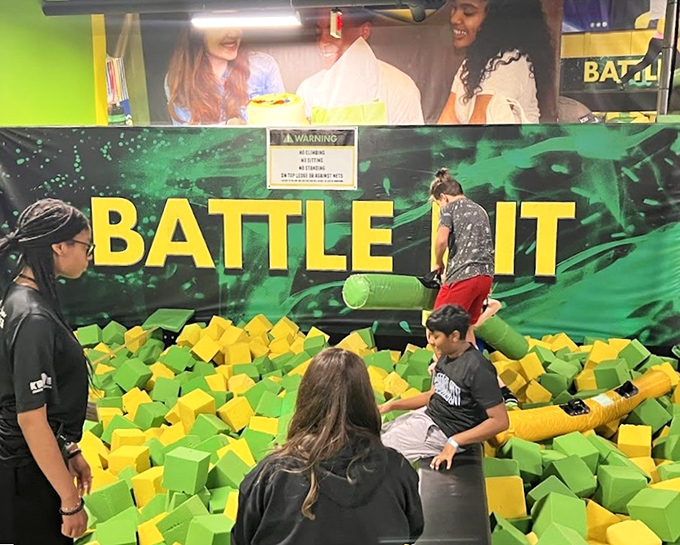 Battle Pit warriors face off above a sea of foam cubes. The falls are soft, but the bragging rights are substantial.