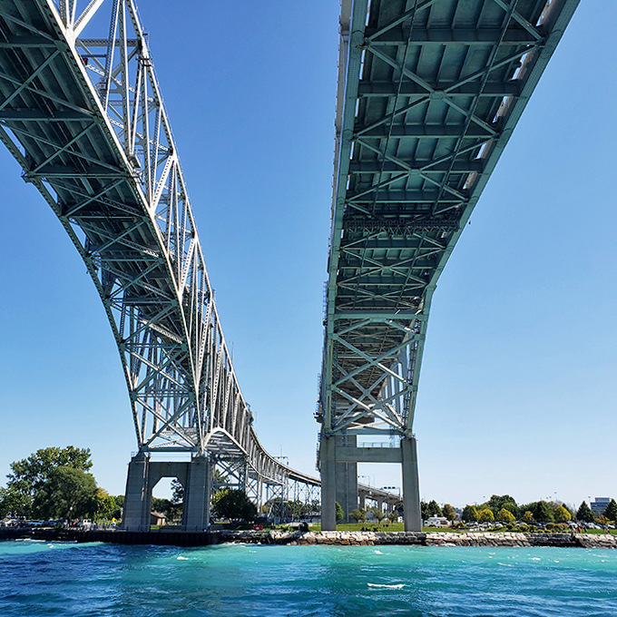 Looking up at the engineering marvel from below &ndash; where massive steel meets blue sky, creating a geometric dance of shadows and light.