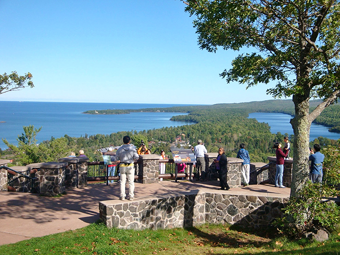 Visitors gather at the stone overlook deck, collectively gasping at Lake Superior's vastness stretching to the horizon.