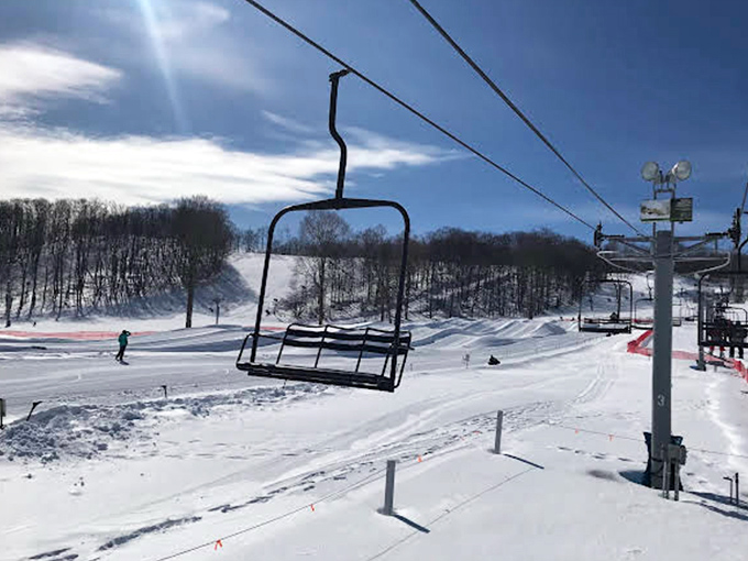 Winter's magic unfolds from this empty chairlift, suspended above pristine snow trails. The calm before the downhill storm!