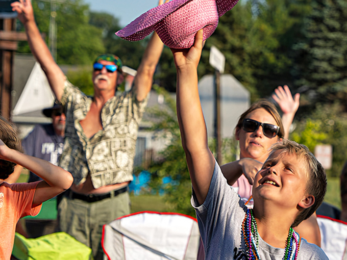 Festival-goers reach skyward for flying treasures, proving that in Caseville, catching beads is serious business that requires proper stretching.