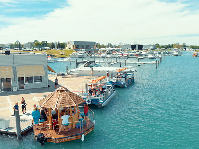 The aerial view reveals the full marina setup, where regular boats look positively boring next to these thatched-roof party platforms cruising the harbor.