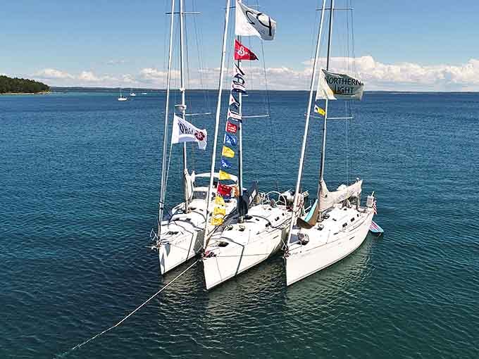 White sails catch the afternoon breeze as boats dance across the bay's surface &ndash; a ballet of wind and water.