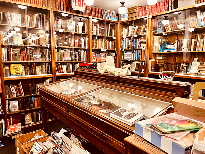 Wooden shelves stretch toward the heavens, their warm patina telling stories of countless hands searching for literary gold over decades.