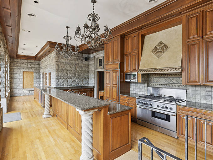 Modern meets historic in this chef's dream kitchen, where professional appliances nestle comfortably alongside classic architectural details and natural stone.