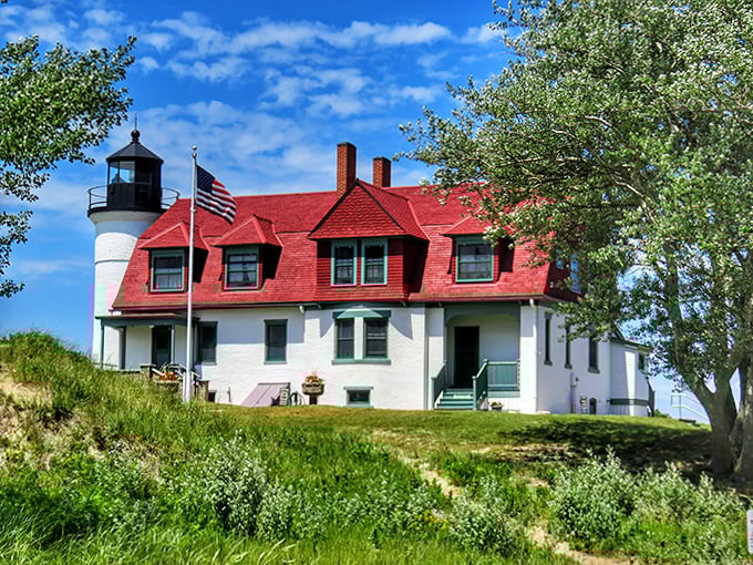 The keeper's house with its distinctive red roof tells stories of maritime history and dedicated lighthouse families.