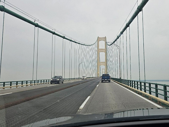 The driver's perspective reveals the bridge's unique grated center lanes, designed to reduce wind resistance during Michigan's notorious gusts.