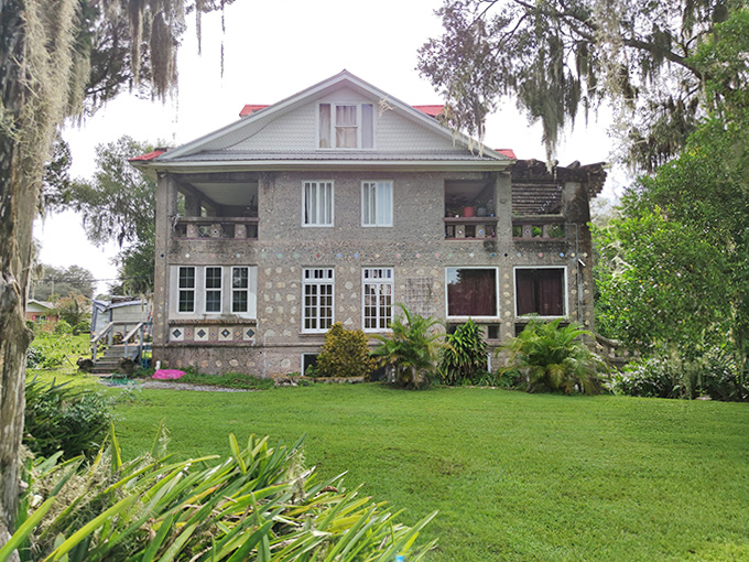 The back of the Wonder House reveals its multi-level design, with porches and balconies offering different perspectives of the lush grounds.