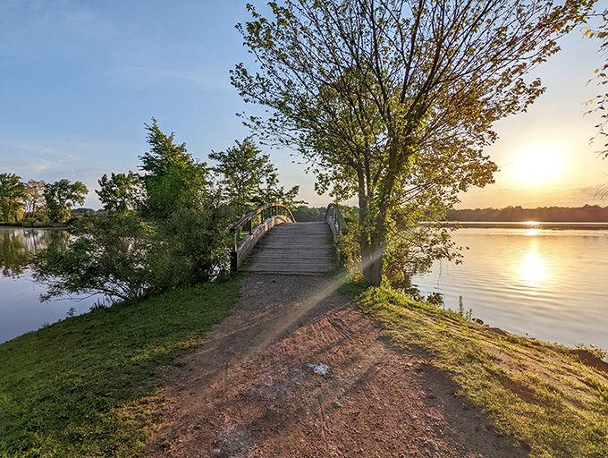 A wooden footbridge arches over calm waters at North Bay Park, where nature offers a peaceful escape just minutes from downtown.