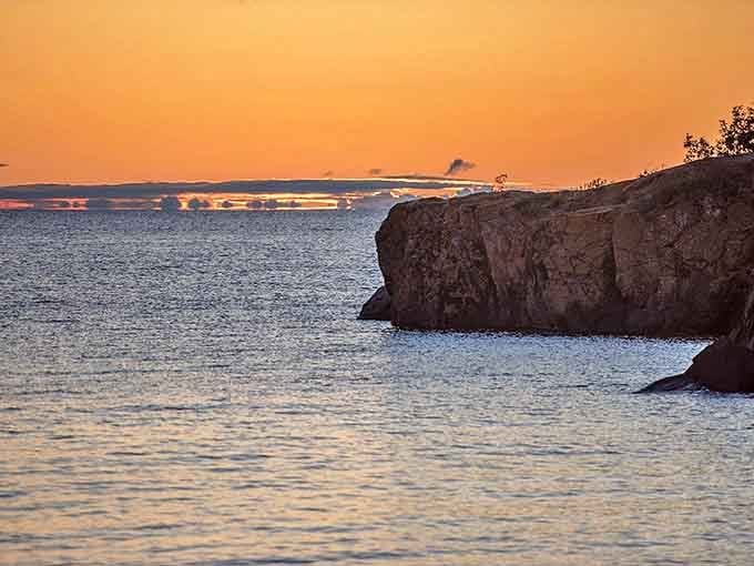The sun bids farewell behind rocky headlands, painting the sky in hues that rival any artist's palette.