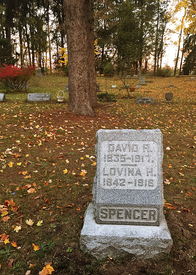 The Spencer family monument stands as a dignified sentinel, its granite surface catching golden light as generations rest together in eternal peace.