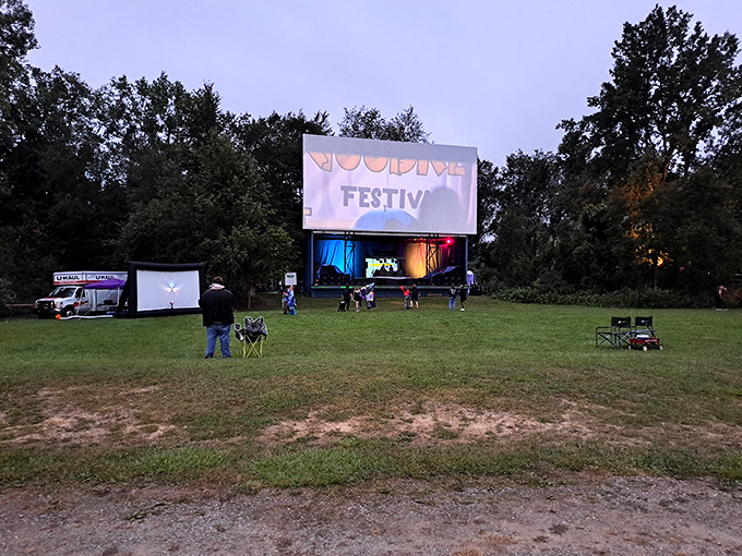 As dusk settles, the towering screen awaits its moment to shine, standing tall against the Michigan sky like a canvas ready for dreams.