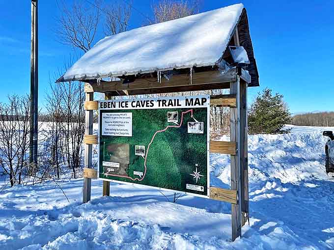 The Eben Ice Caves trail map stands sentinel in winter, a snow-capped guide to Michigan's hidden frozen treasure.