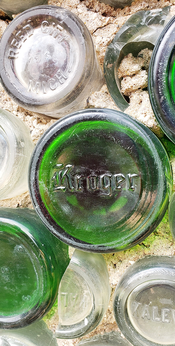 Antique bottles embedded in the walls reveal their original branding &ndash; Reed City Michigan and Kroger among them &ndash; each one a tiny time capsule.