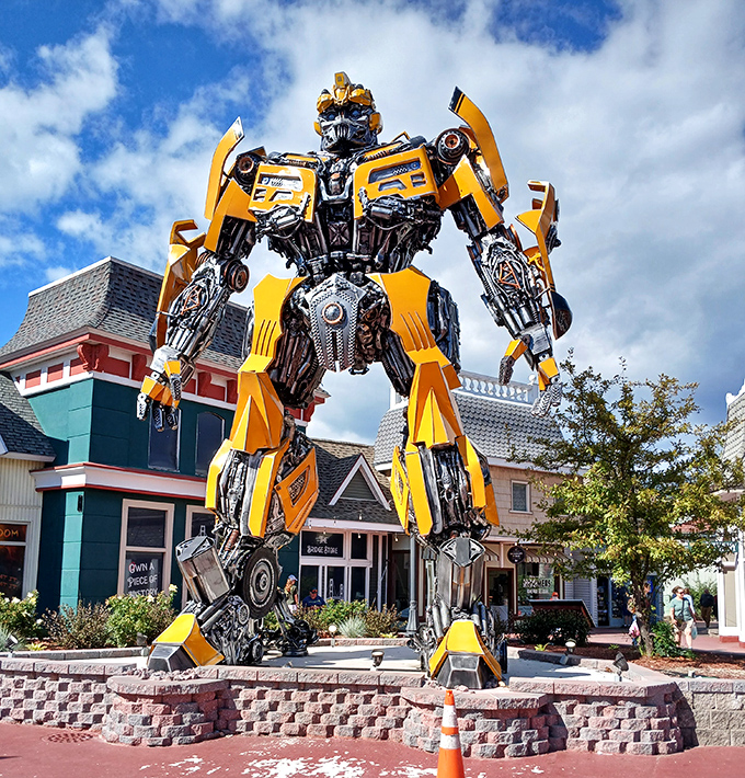 The front view showcases Mack-A-Tron's impressive stature against the quaint shopping district backdrop, creating a delightful visual contradiction that somehow works perfectly.