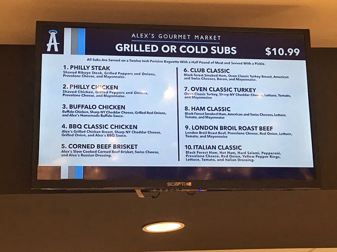 The menu board showcases ten tempting sub options, from classic Philly steak to Italian favorites – each promising a half-pound of meat on twelve-inch perfection.