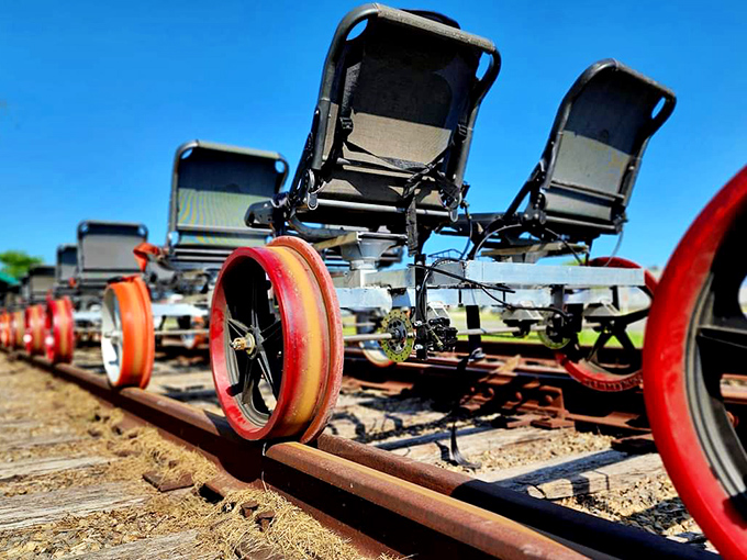 A lineup of ingeniously designed rail bikes awaits their riders, their bright orange wheels ready to roll along historic tracks.