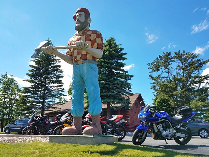 From this angle, Paul's impressive stature dominates the landscape, his blue pants and work boots ready for legendary woodland adventures.