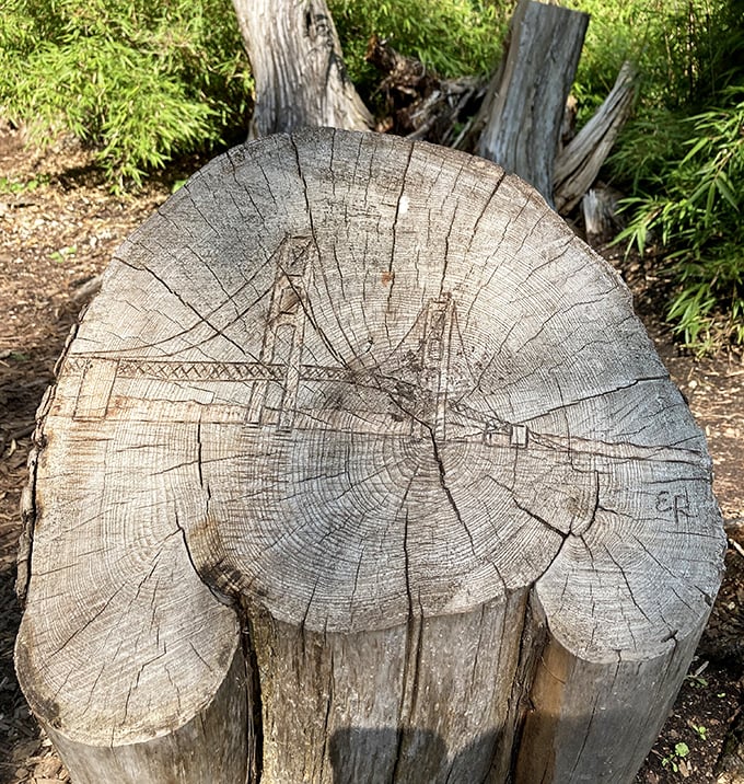 Even fallen trees find new purpose here &ndash; this stump carved with the Mackinac Bridge reminds visitors of their journey to this floral paradise.